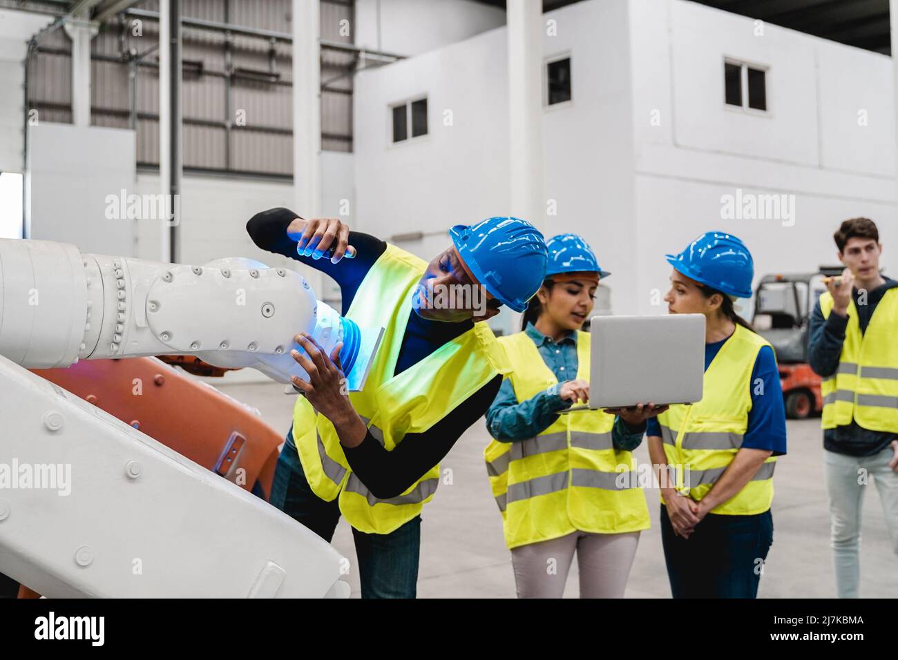 Multiethnic engineers working together inside automation and robotics ...