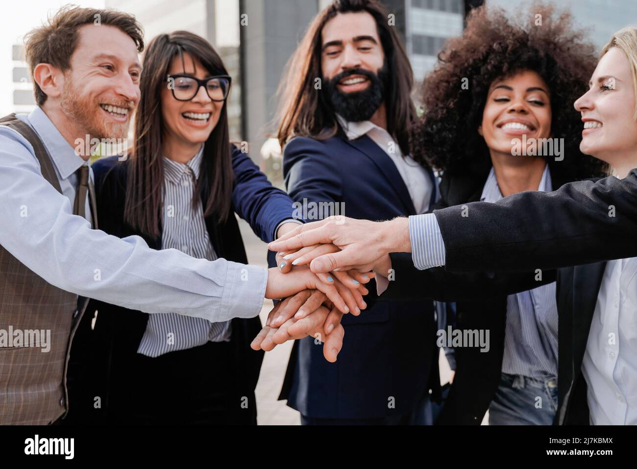 Multiethnic business people stacking hands with colleagues outdoor with ...