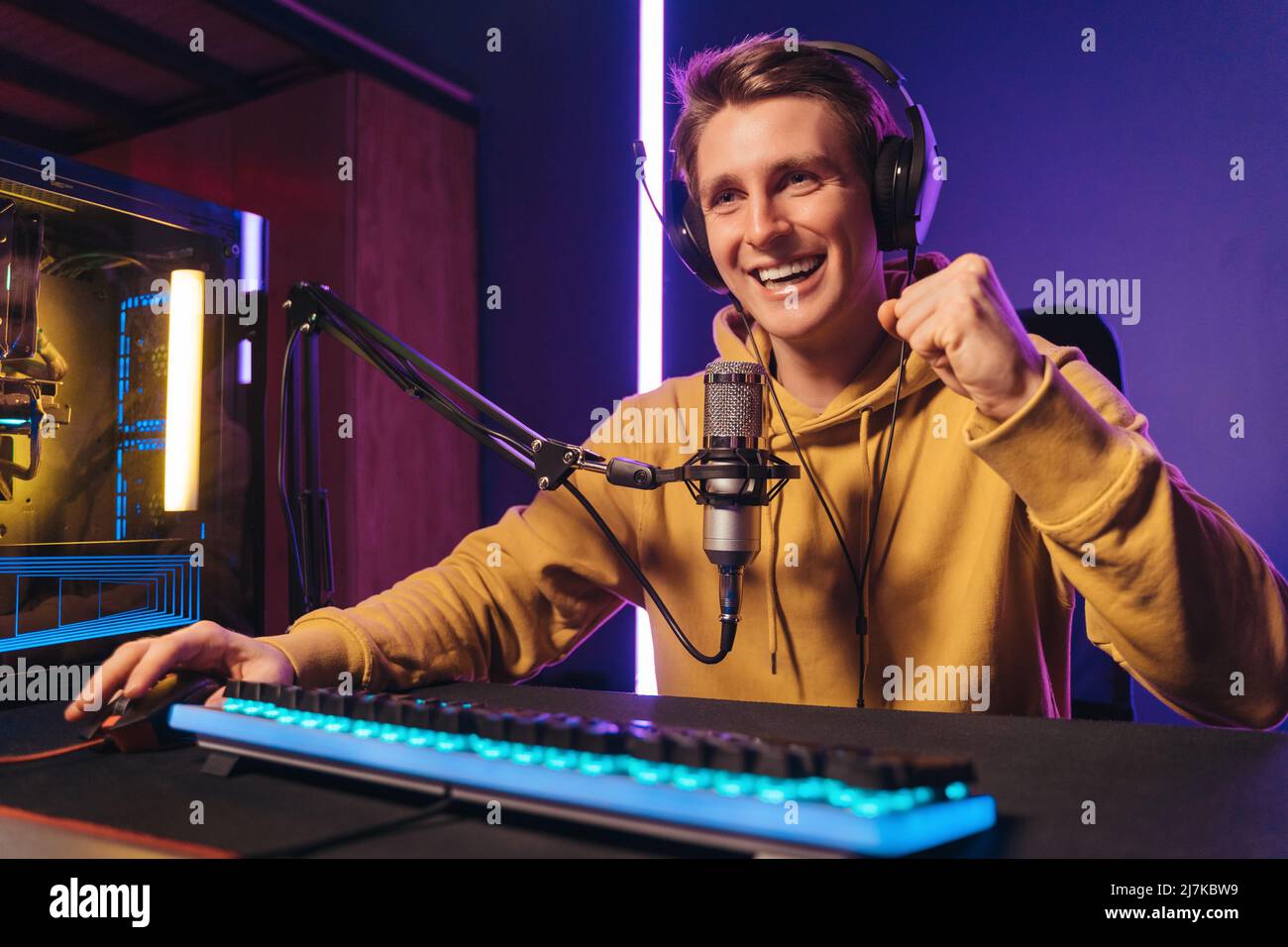 Pro gamer wearing professional headphones feels exited about victory in ...