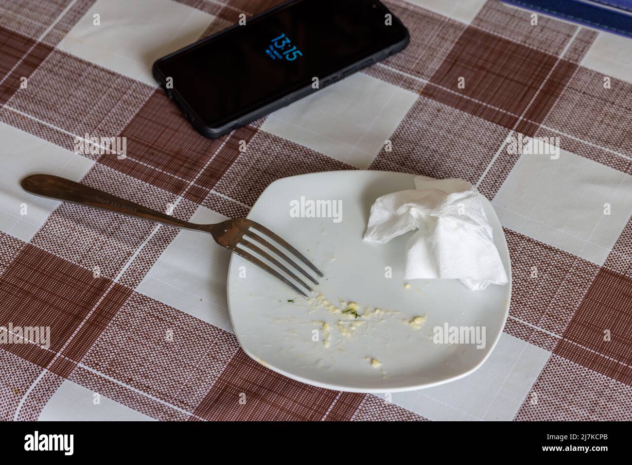 empty white dish with leftovers of eaten food, crumpled table-napkin ...