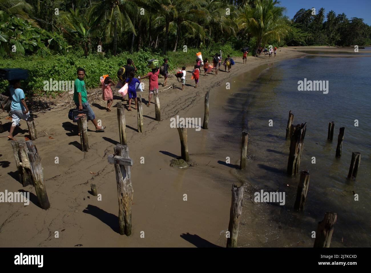 Local people carrying luggages belong to tourists, walking along the ...