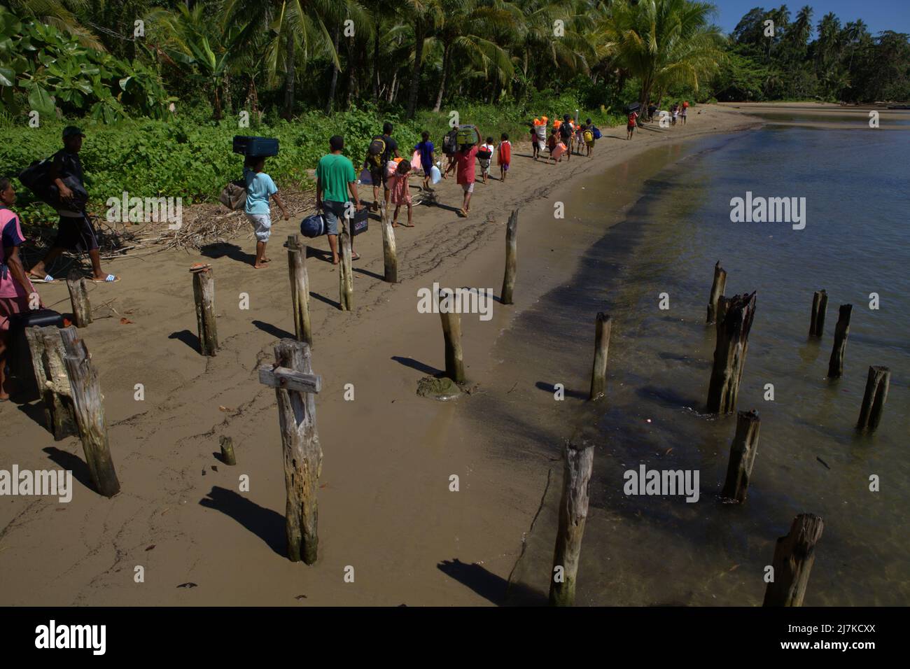 Local people carrying luggages belong to tourists, walking along the ...