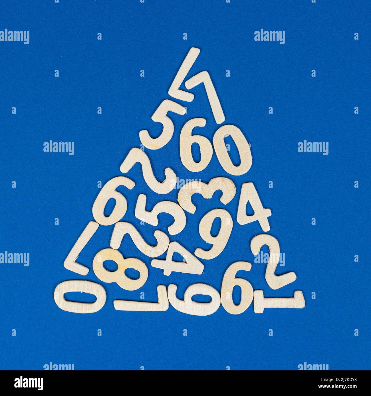 the shape of the triangle formed with wooden numbers on a blue ...
