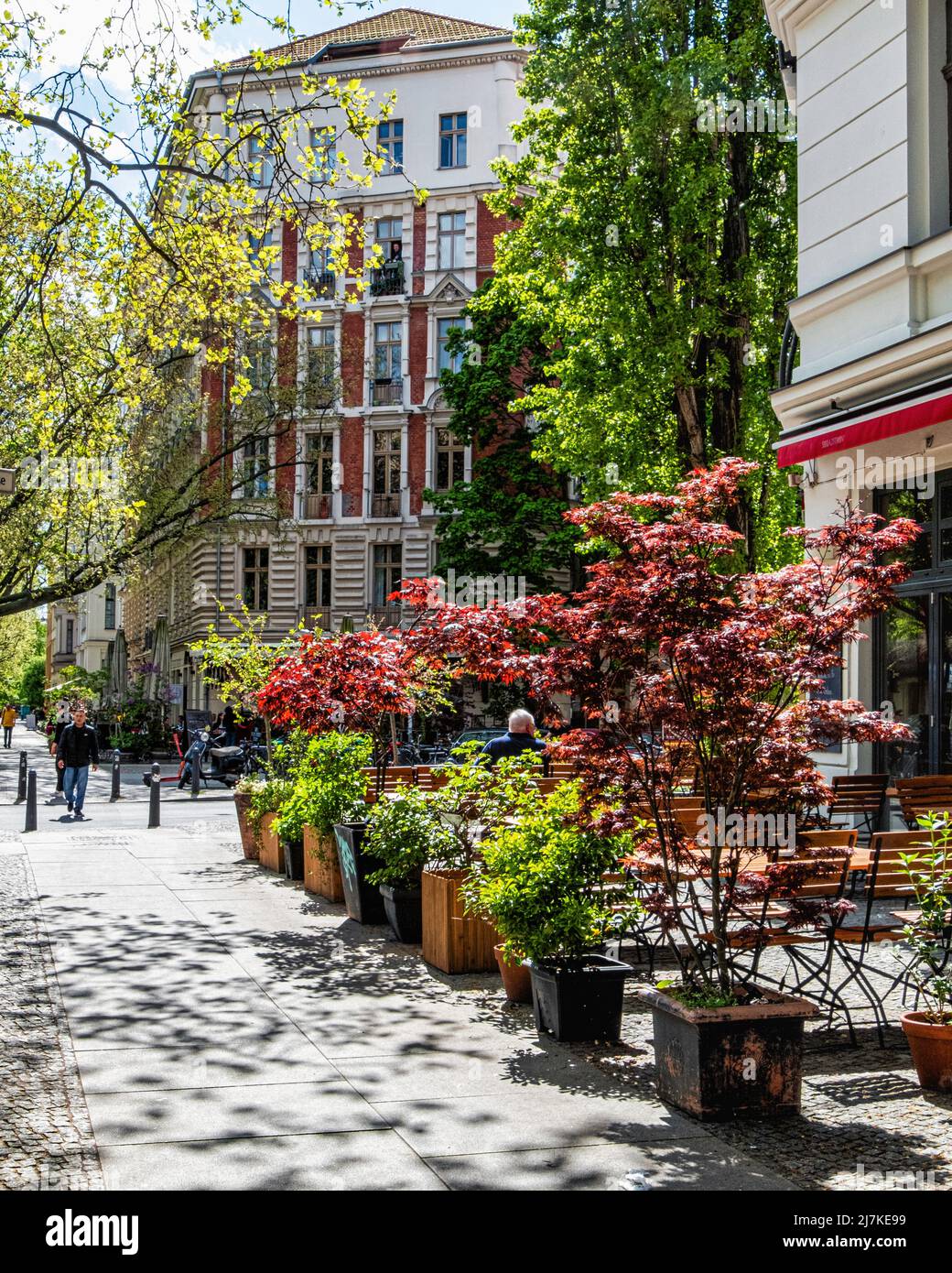 Street view of Apartment building and tables of restaurant in Spring ...