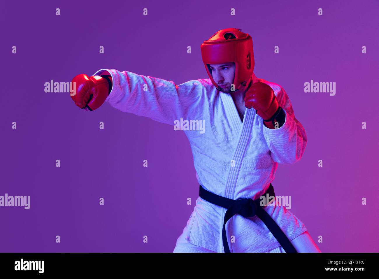 Studio shot of male taekwondo fighter in sports uniform in action ...