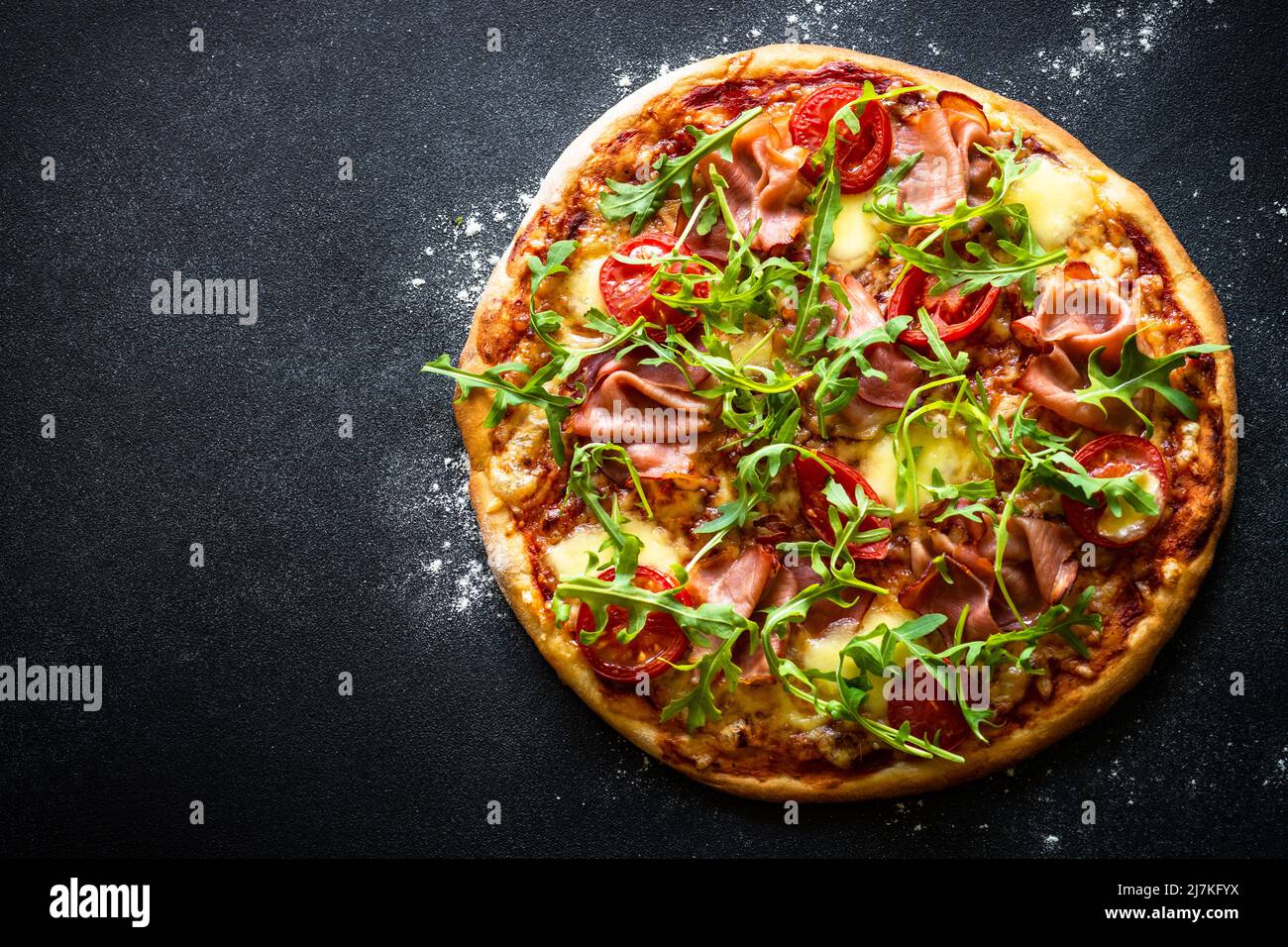 Traditional italian pizza with ham, cheese, tomatoes and arugula Stock ...