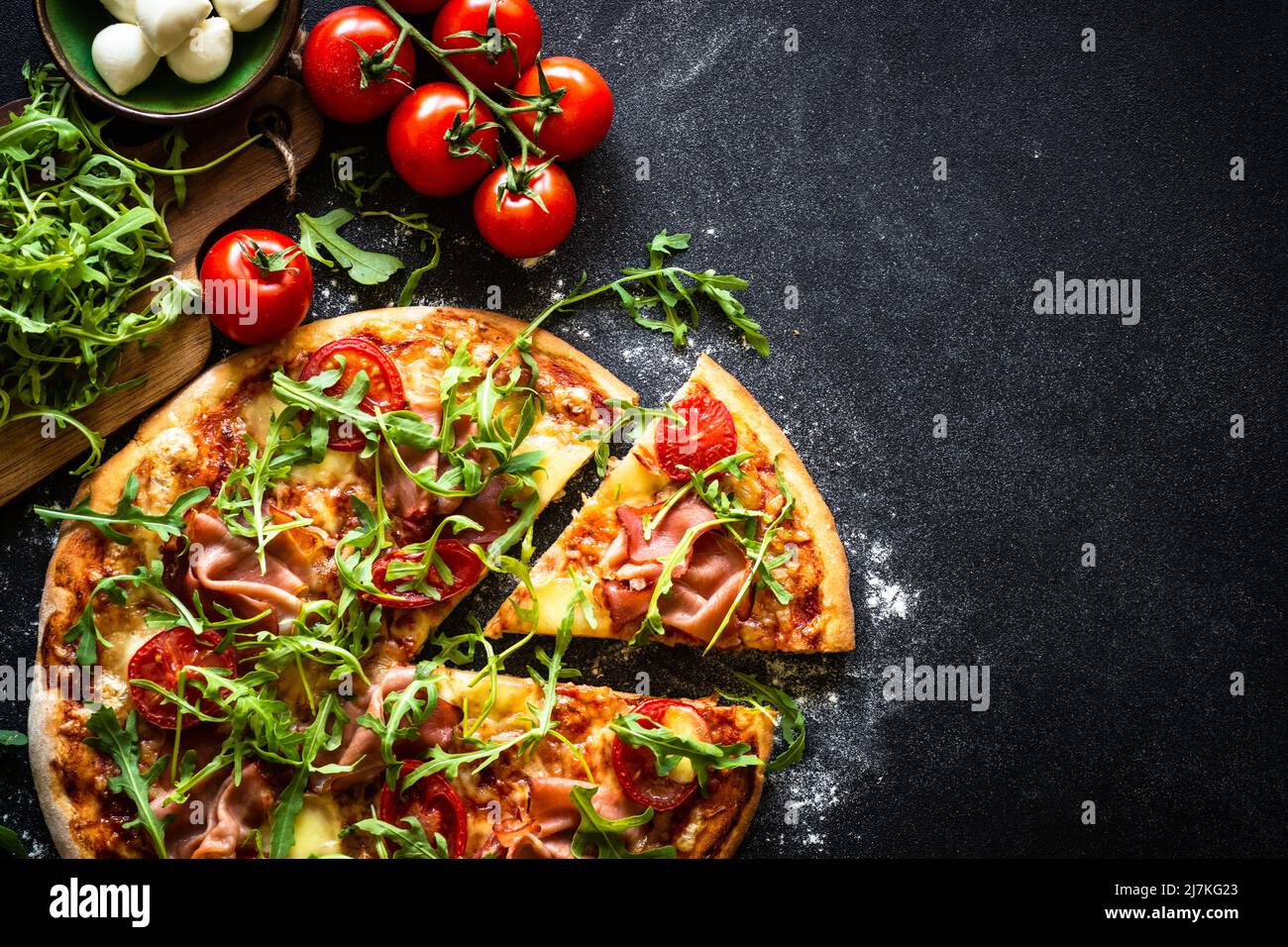 Traditional italian pizza with ham, cheese, tomatoes and arugula Stock ...