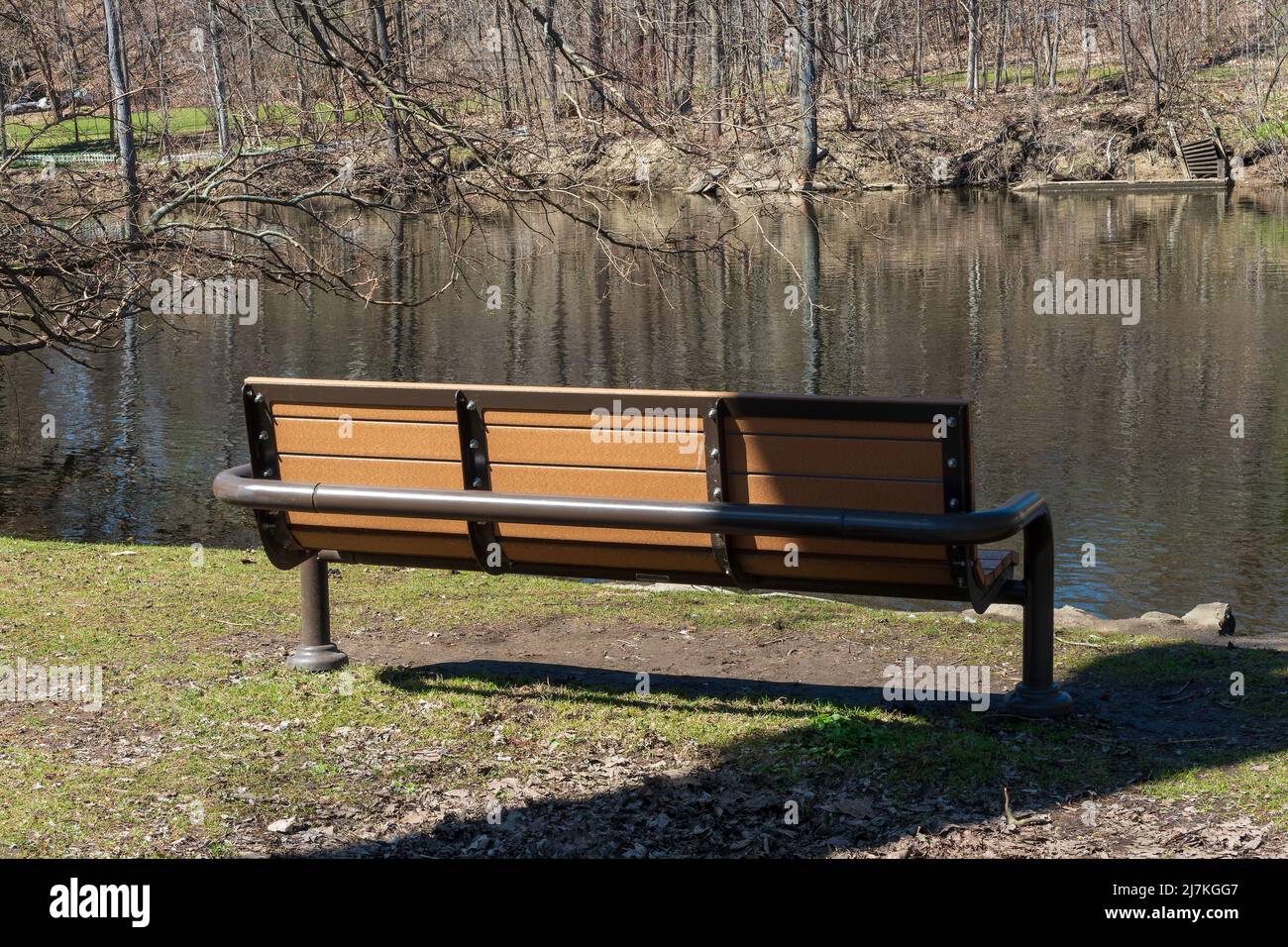 Empty composite park bench overlooking a peaceful river Stock Photo - Alamy