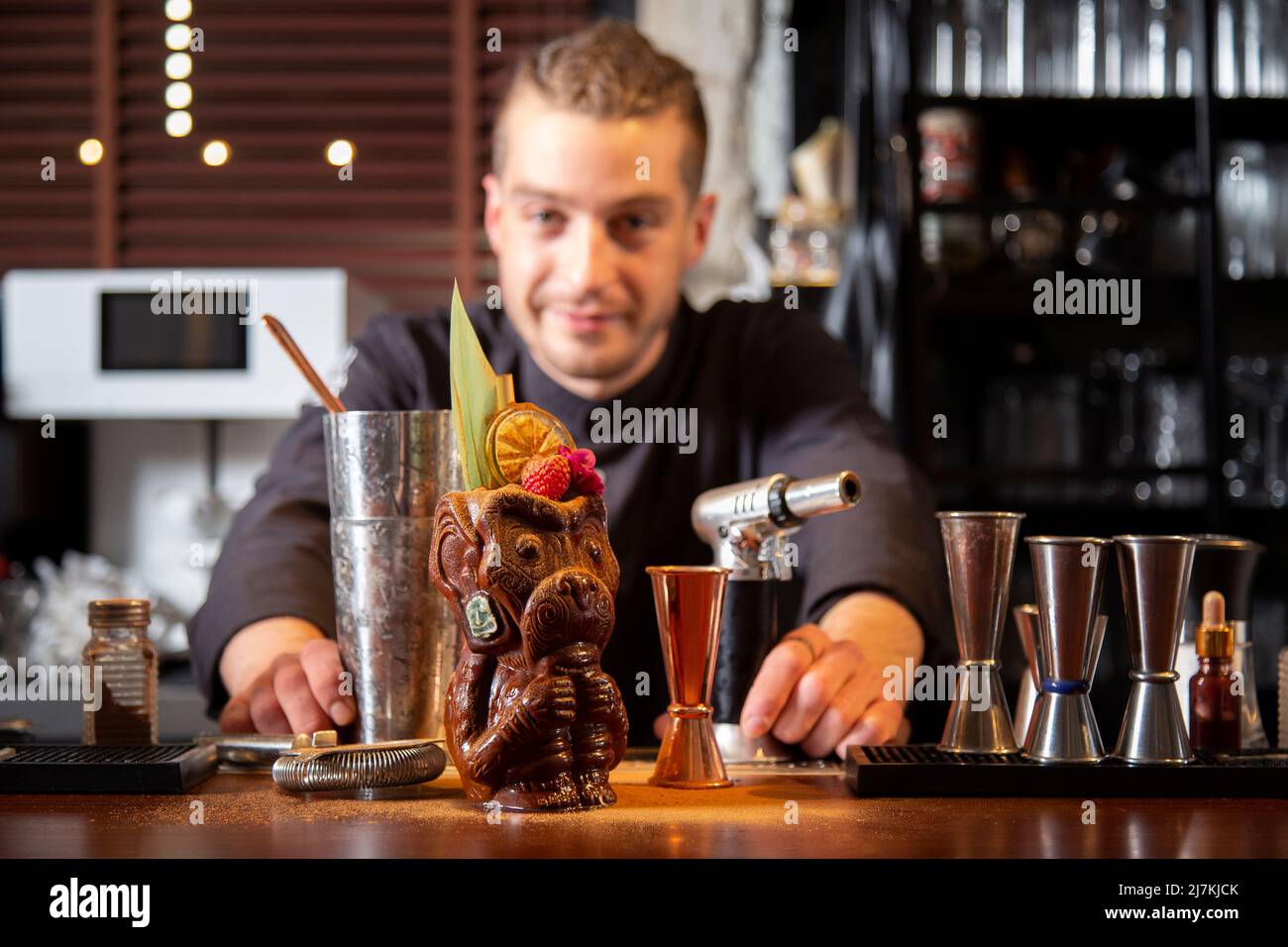 Self assured young professional barman with trendy braided hairstyle ...
