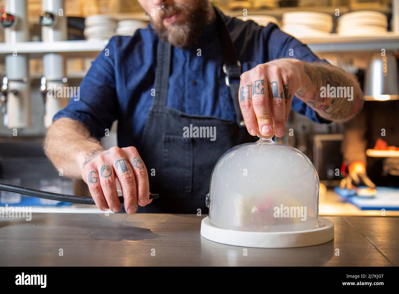 Crop unrecognizable male chef extracting hose from glass smoking dome ...