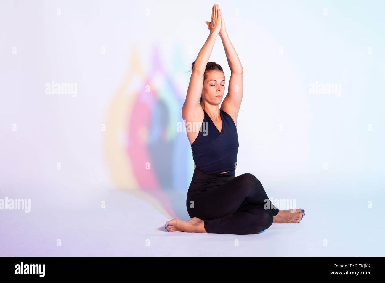 Full body of peaceful female with closed eyes meditating in Padmasana ...