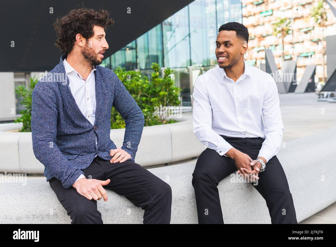 Content multiracial businessmen in formal wear talking to each other ...