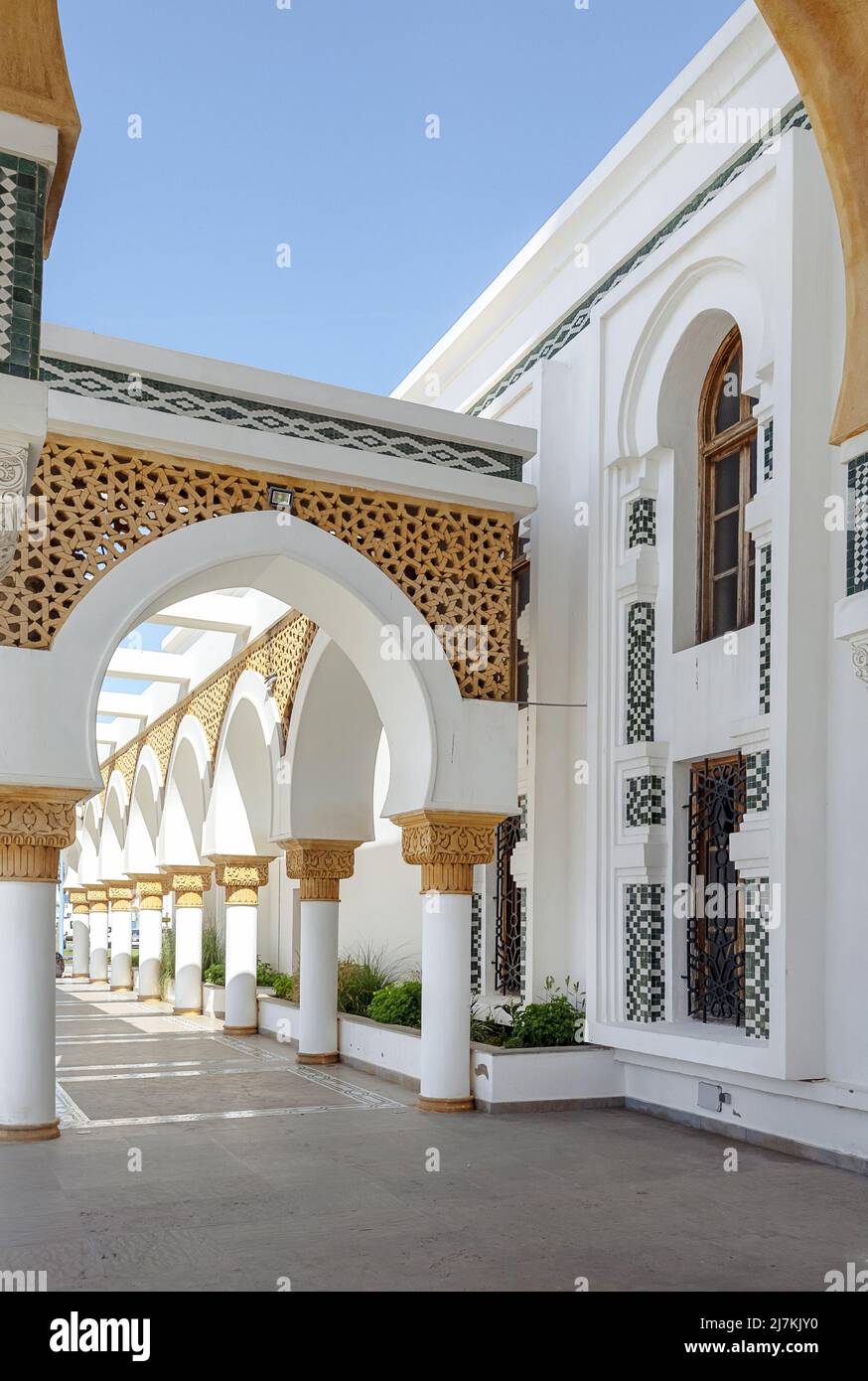 Long empty pathway between columns with ornamental elements and arched ...