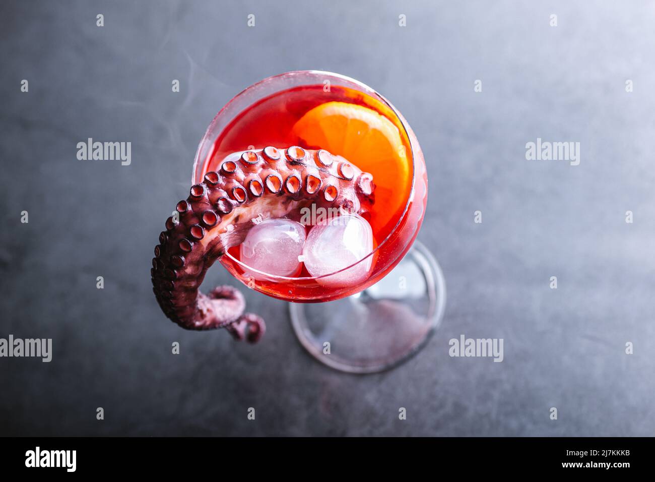 From above alcoholic cocktail with ice cubes served with octopus ...