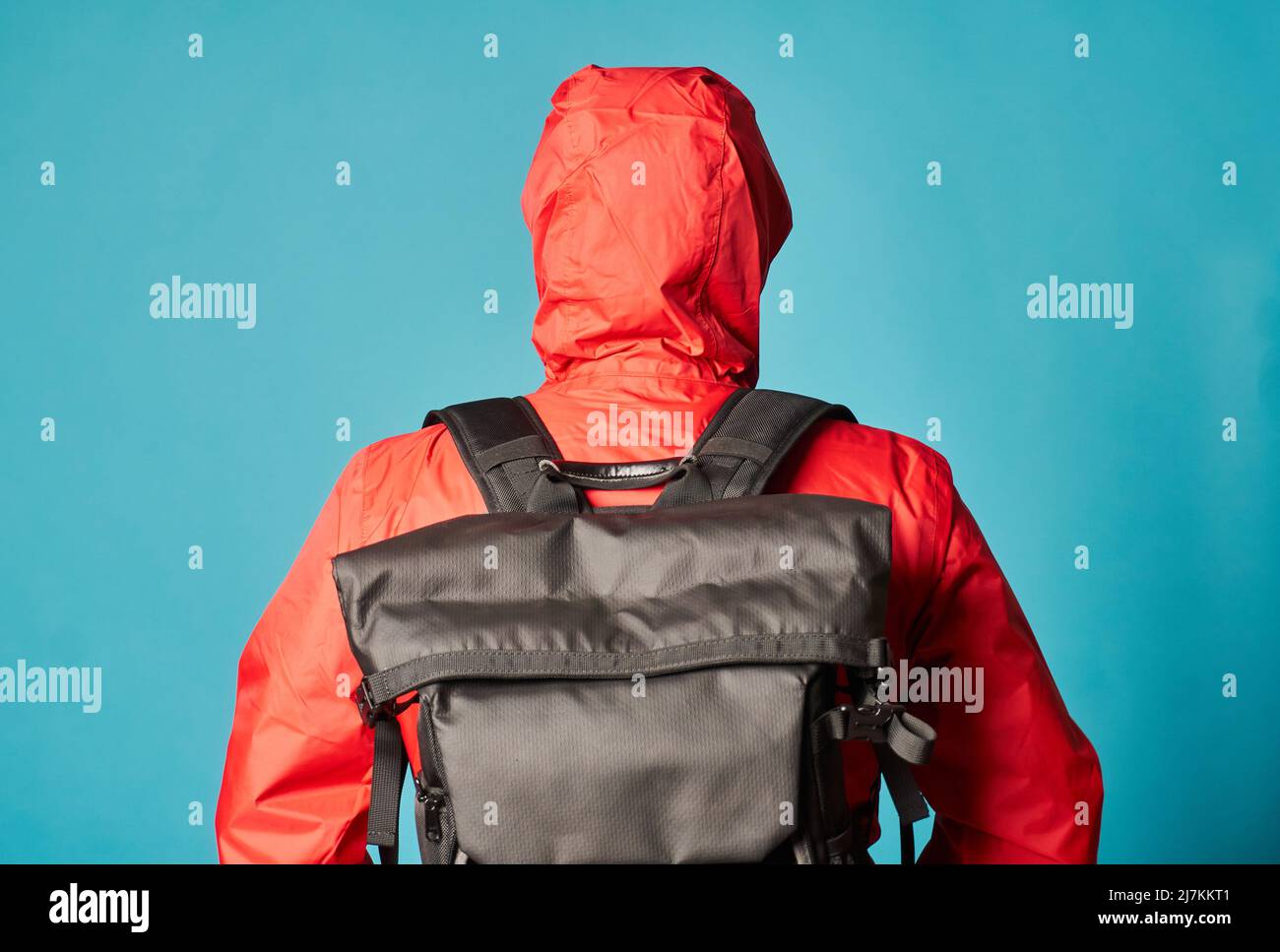 Back view anonymous tourist in red jacket and backpack standing near ...