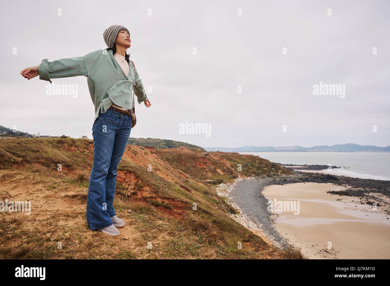 Side view asian girl with closed eyes feeling freedom in the seaside in ...