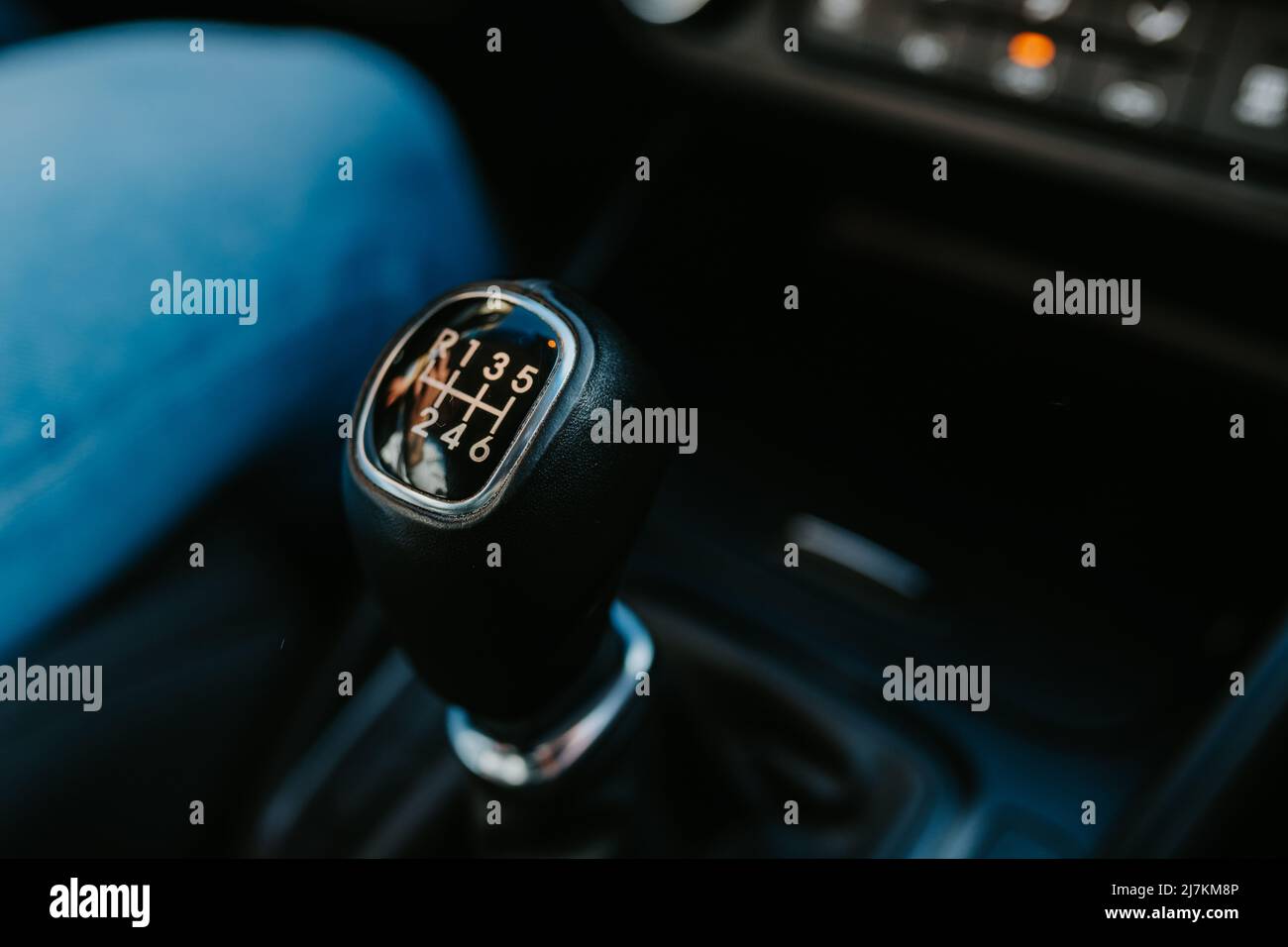 Crop anonymous driver in jeans sitting near black six speed manual ...