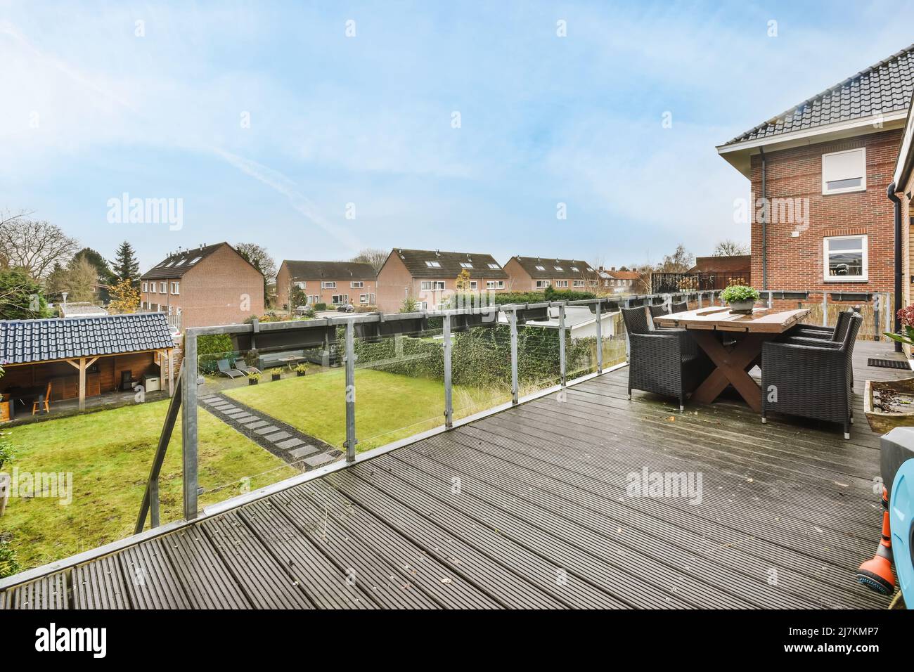 Terrace with table and chairs located in backyard of brick cottage with ...