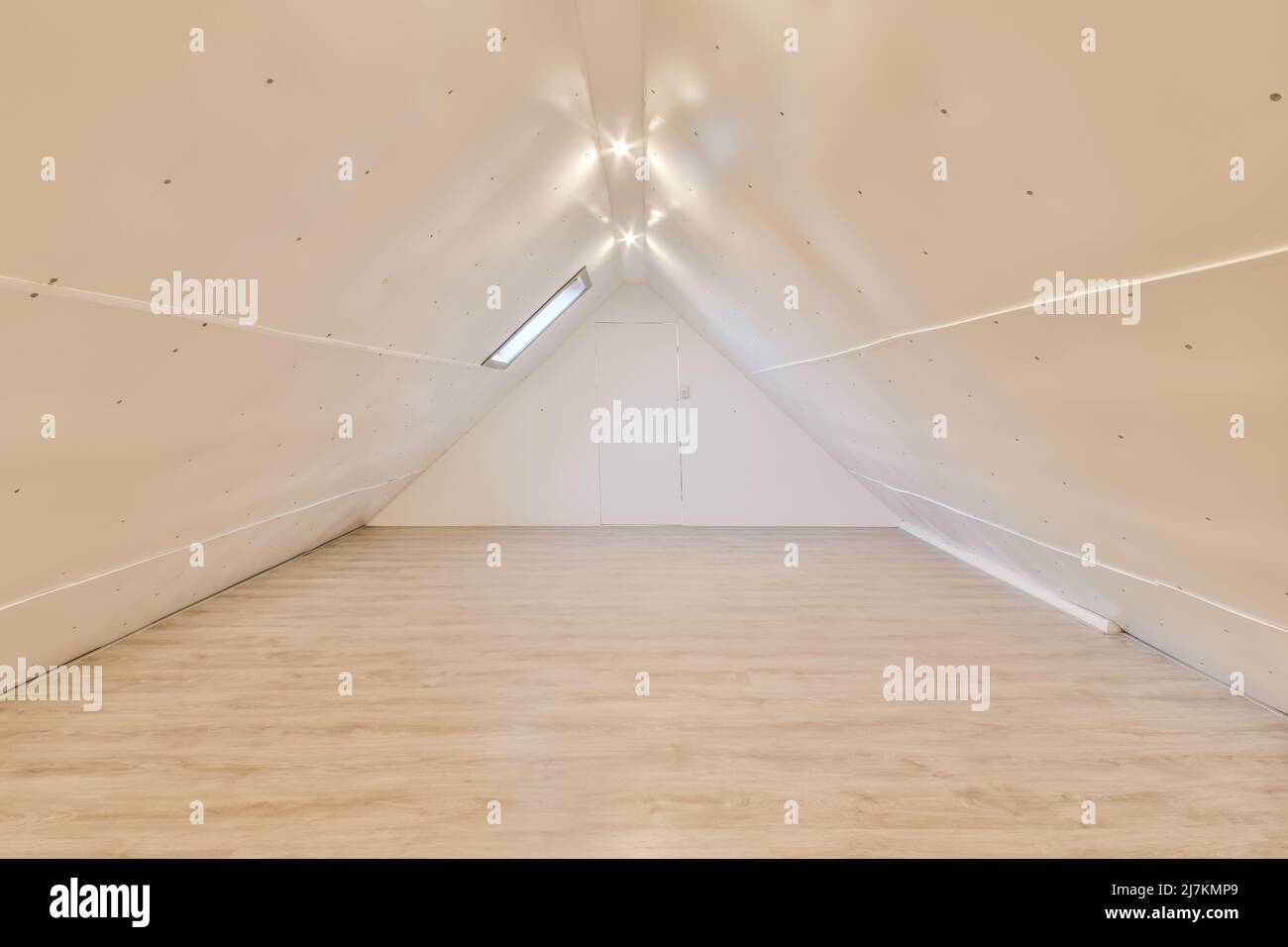 Interior of spacious light attic room with white walls and without ...