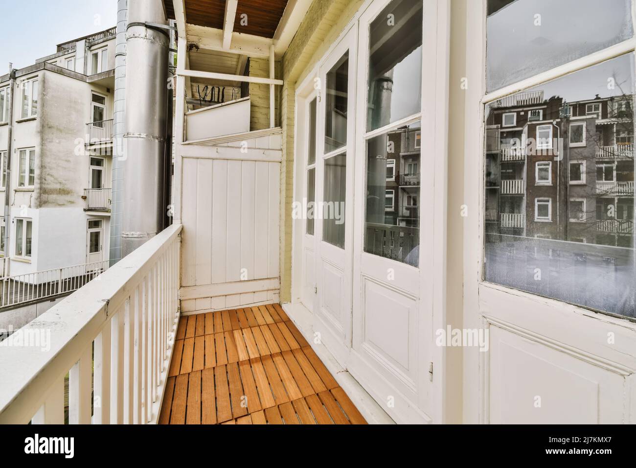 Balcony of residential building with glass doors with reflection and ...
