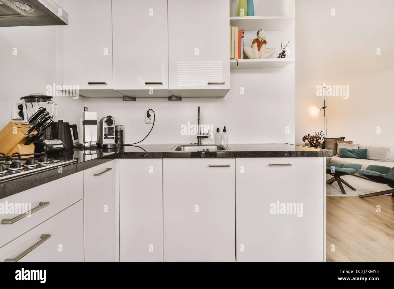 Counter with white cabinets and utensils placed in light stylish ...
