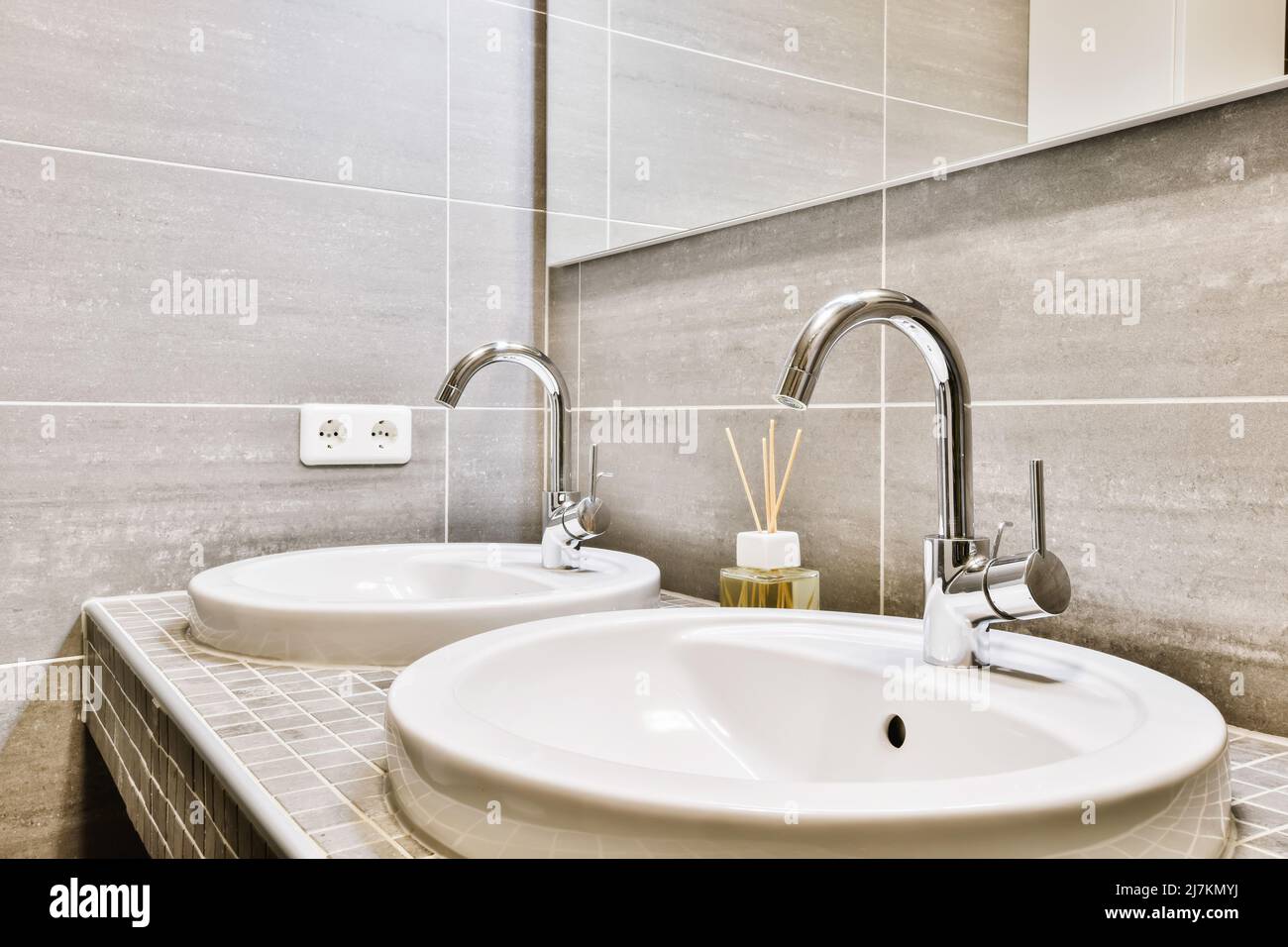Shiny chrome faucets attached to double ceramic sink in modern bathroom ...