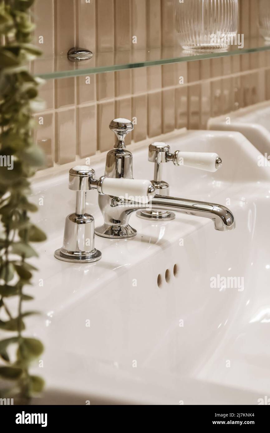 Elegant chrome classic styled faucet on white ceramic sink in modern ...