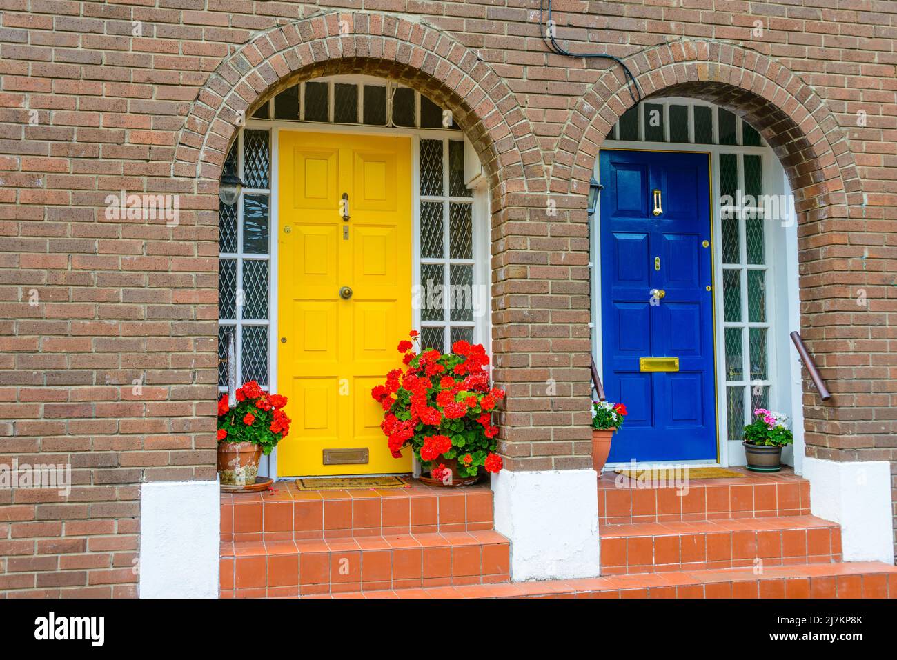 Exterior of brick residential house with colorful entrance doors and ...