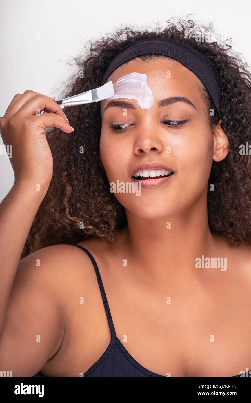 Self assured young ethnic female model with curly dark hair and in ...