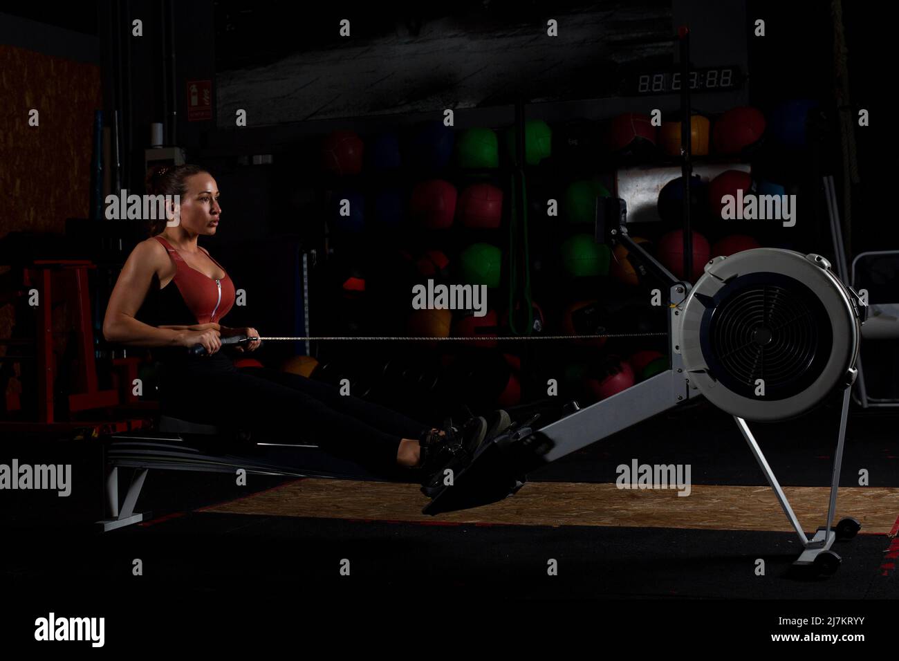 Side view of determined muscular female athlete doing seated cable row ...