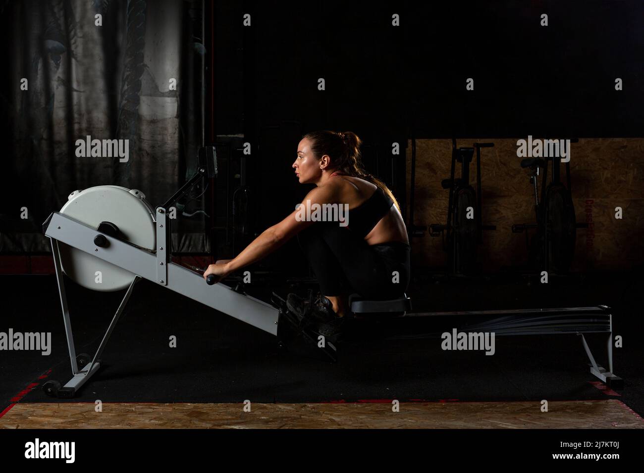 Side view of determined muscular female athlete doing seated cable row ...