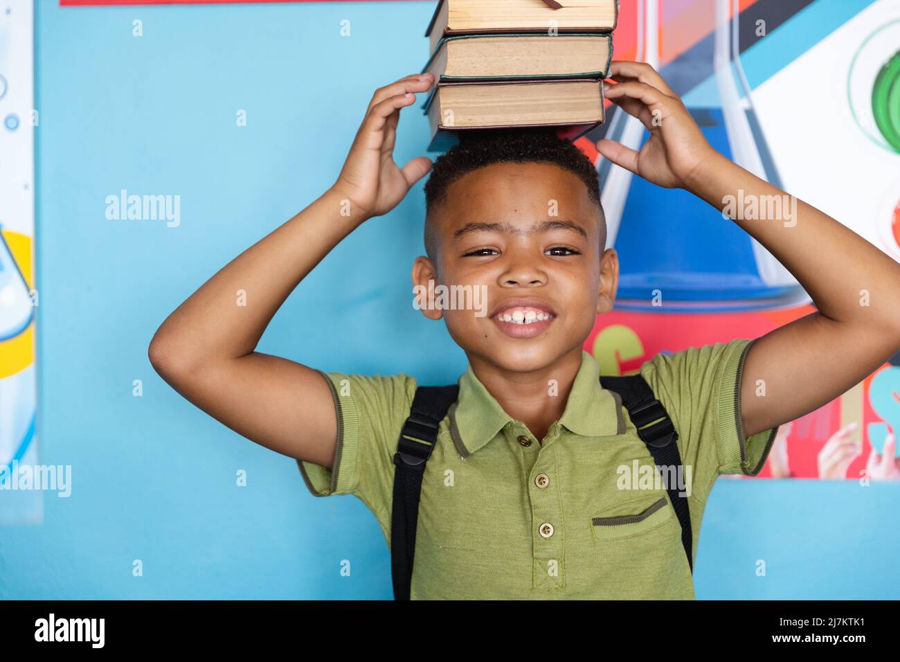 Portrait of smiling african american elementary schoolboy stacking ...
