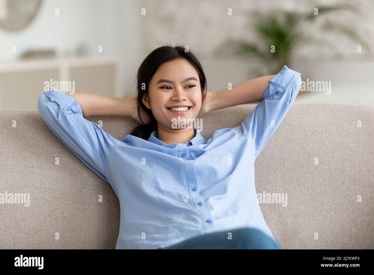 Cute chinese woman resting on sofa at home Stock Photo - Alamy