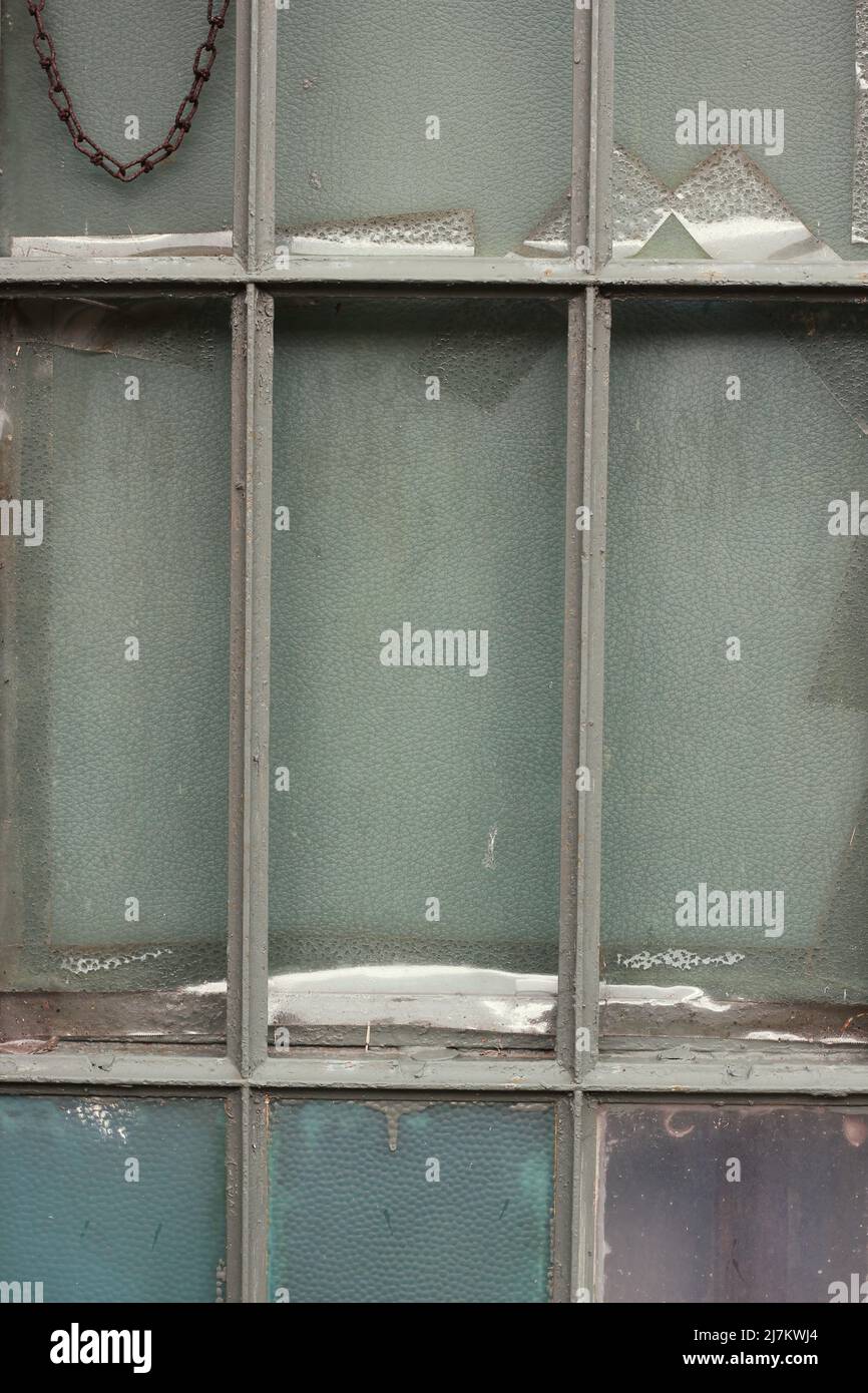 Worn old weathered pane glass window on the wall of an abandoned ...