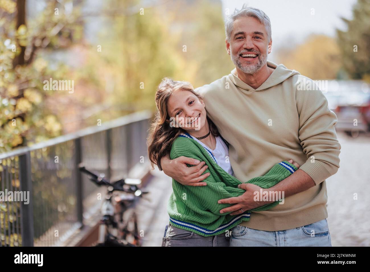 Teenage daughter hugging her father outside in town when spenidng time ...
