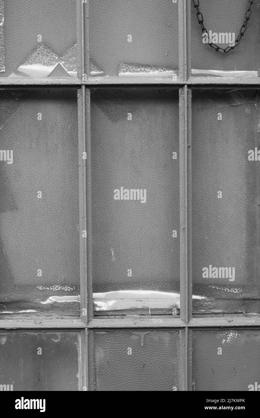 Worn old weathered pane glass window on the wall of an abandoned ...