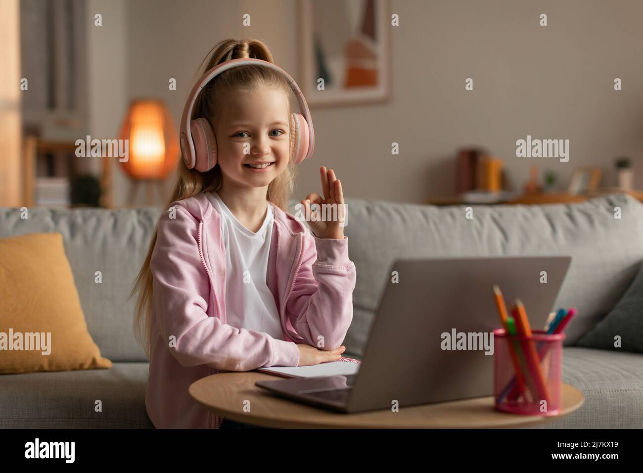 Little Girl Using Laptop Gesturing Okay Learning Online At Home Stock ...