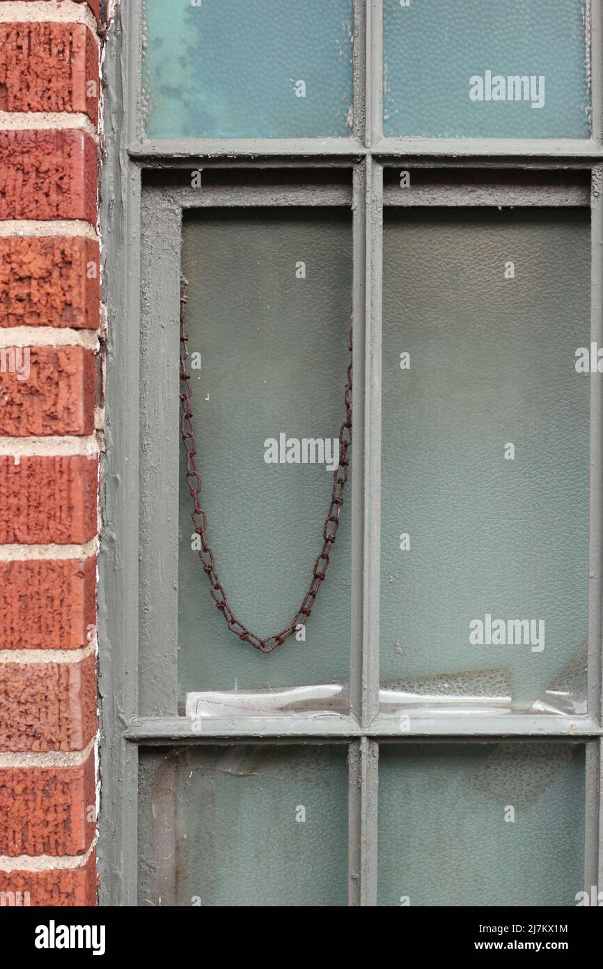 Worn old weathered pane glass window on the wall of an abandoned ...