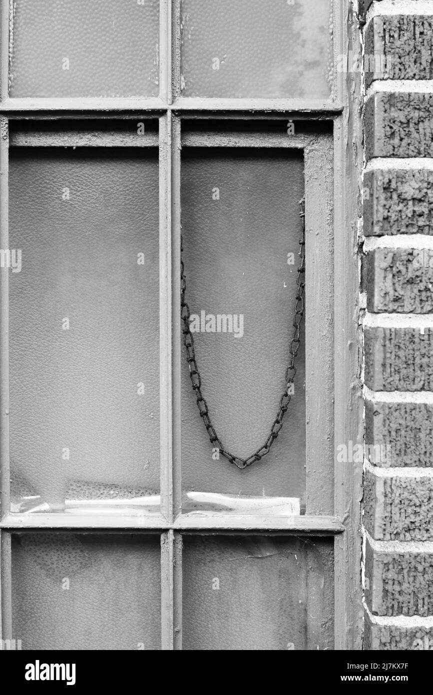 Worn old weathered pane glass window on the wall of an abandoned ...