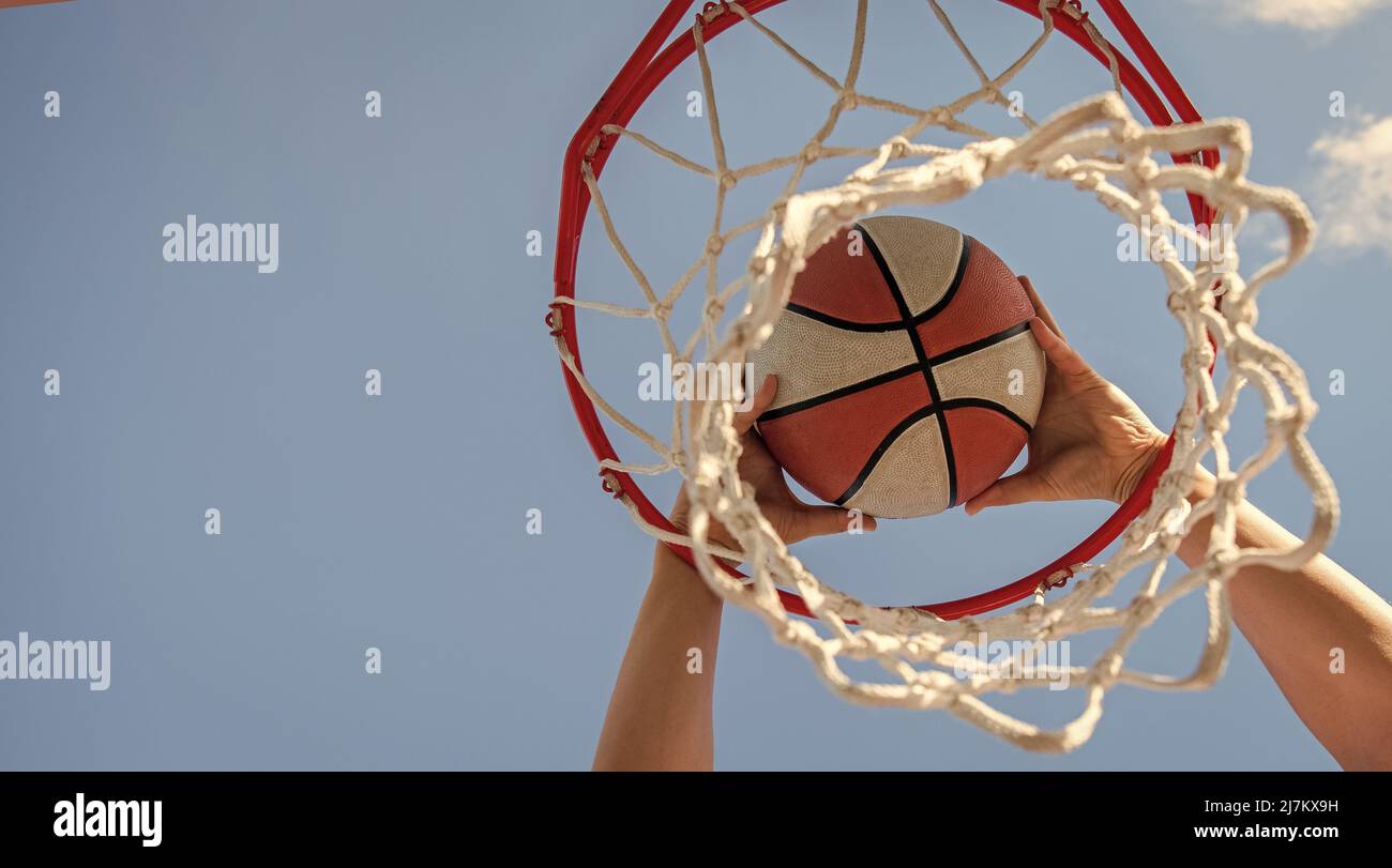 basketball ball flying through basket in players hands, copy space ...