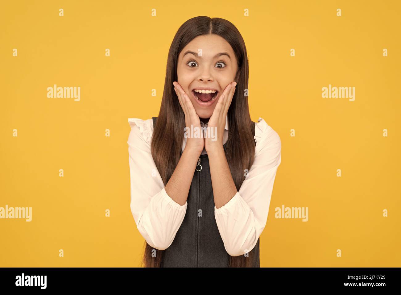 Surprised primary school kid in uniform yellow background, surprise ...