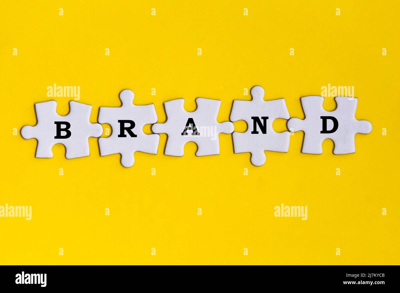 Brand text on missing jigsaw puzzle on yellow cover background ...