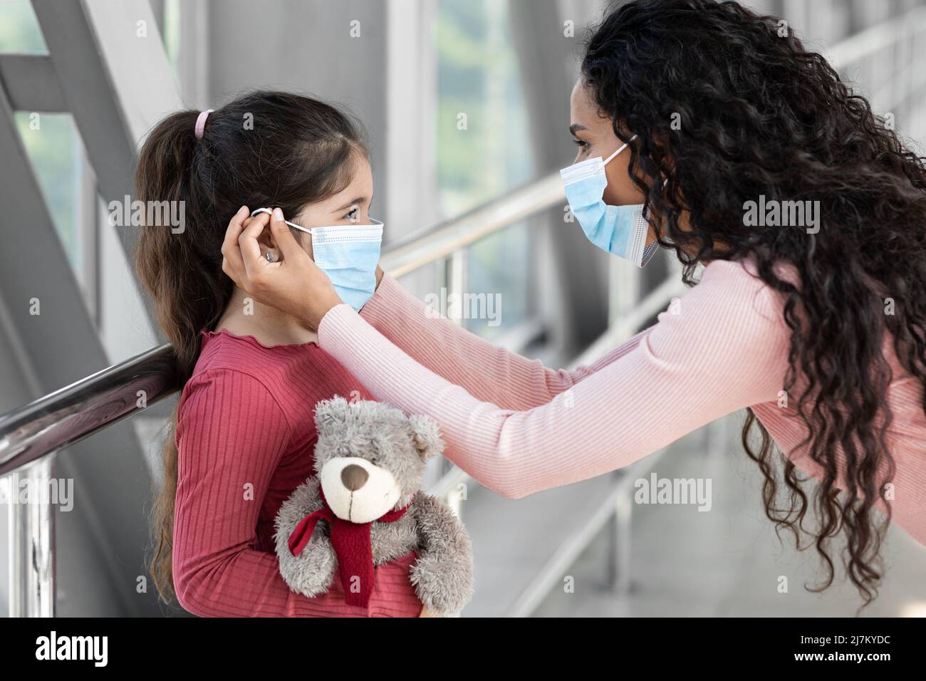 Caring Young Mom Wearing Protective Medical Mask To Her Daughter At ...