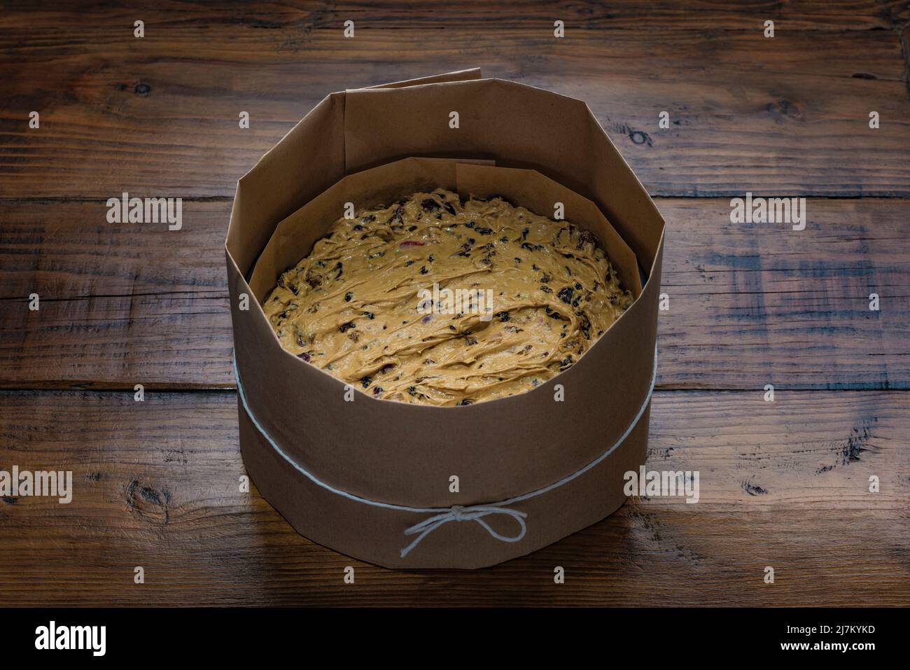 Fruit cake batter in a round tin lined with baking parchment, with ...