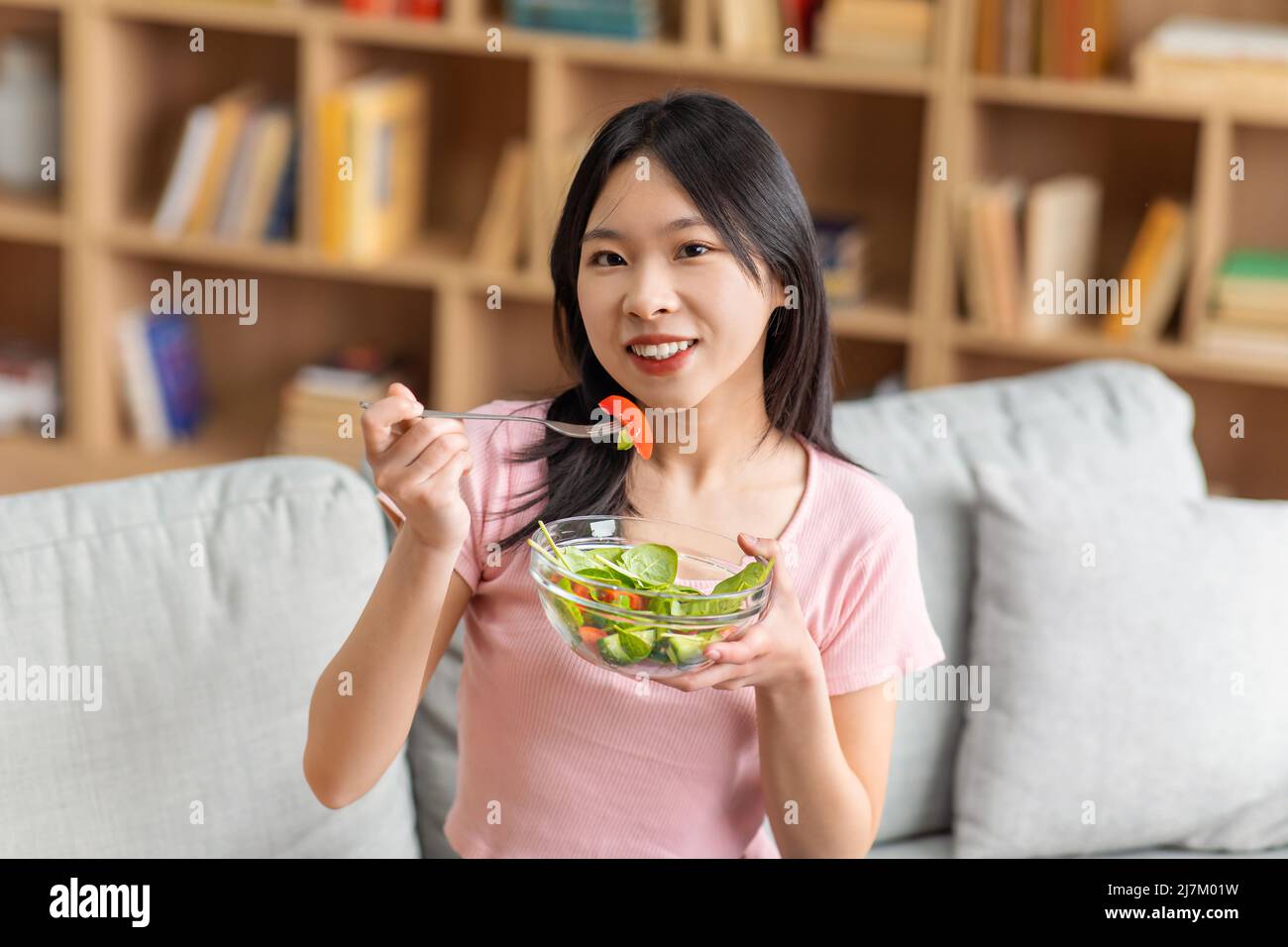 Healthy nutrition concept. Young asian lady eating yummy vegetable ...