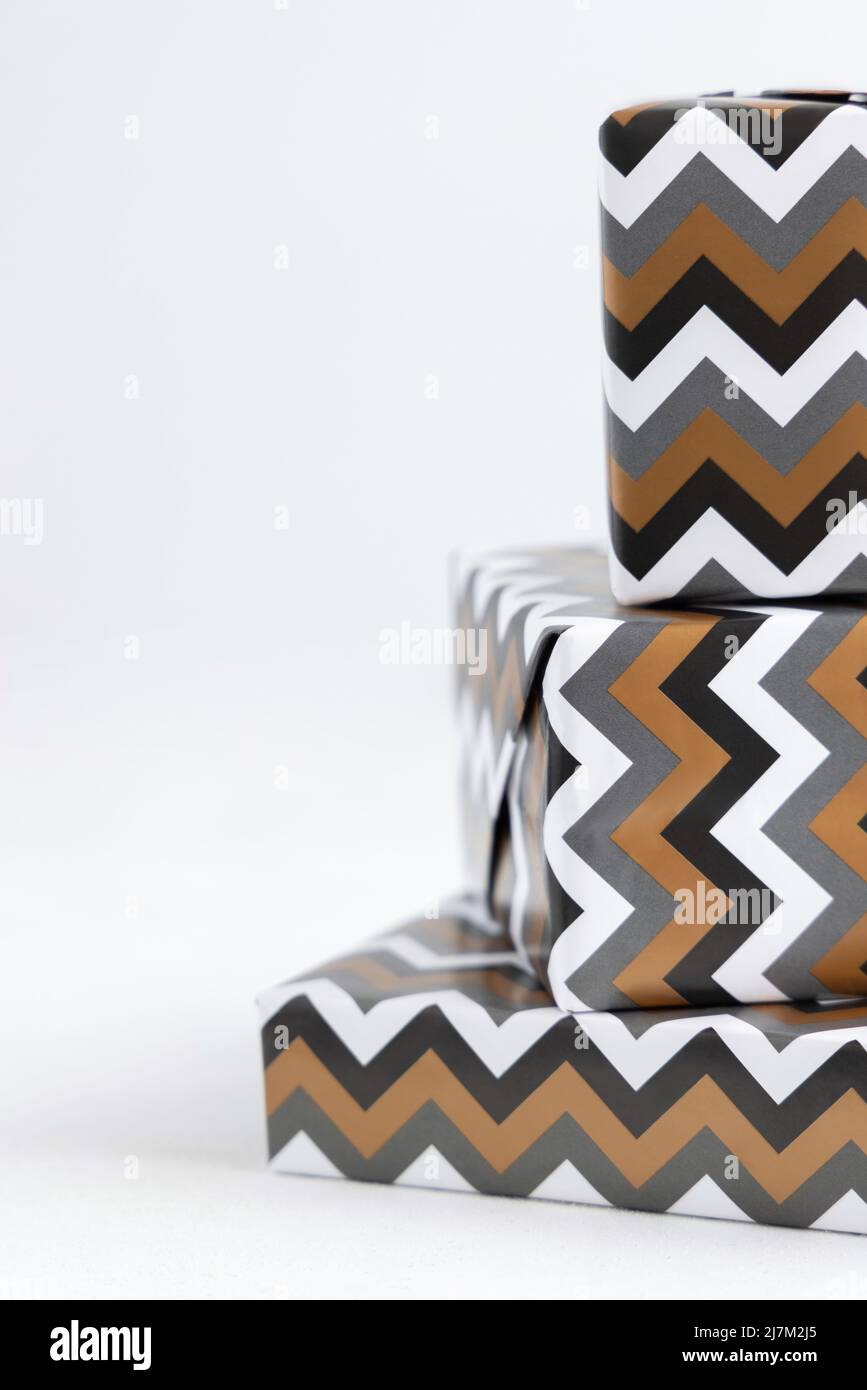 Presents Wrapped in chevron geometric paper on white table close up ...
