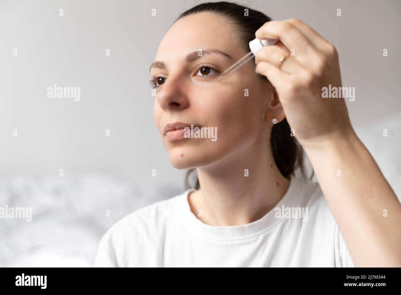 Close up of white woman hand applying oil of essential oil or serum for ...