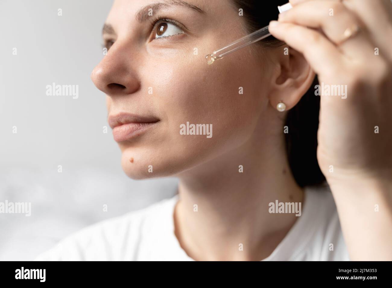 Close up of white woman hand applying oil of essential oil or serum for ...