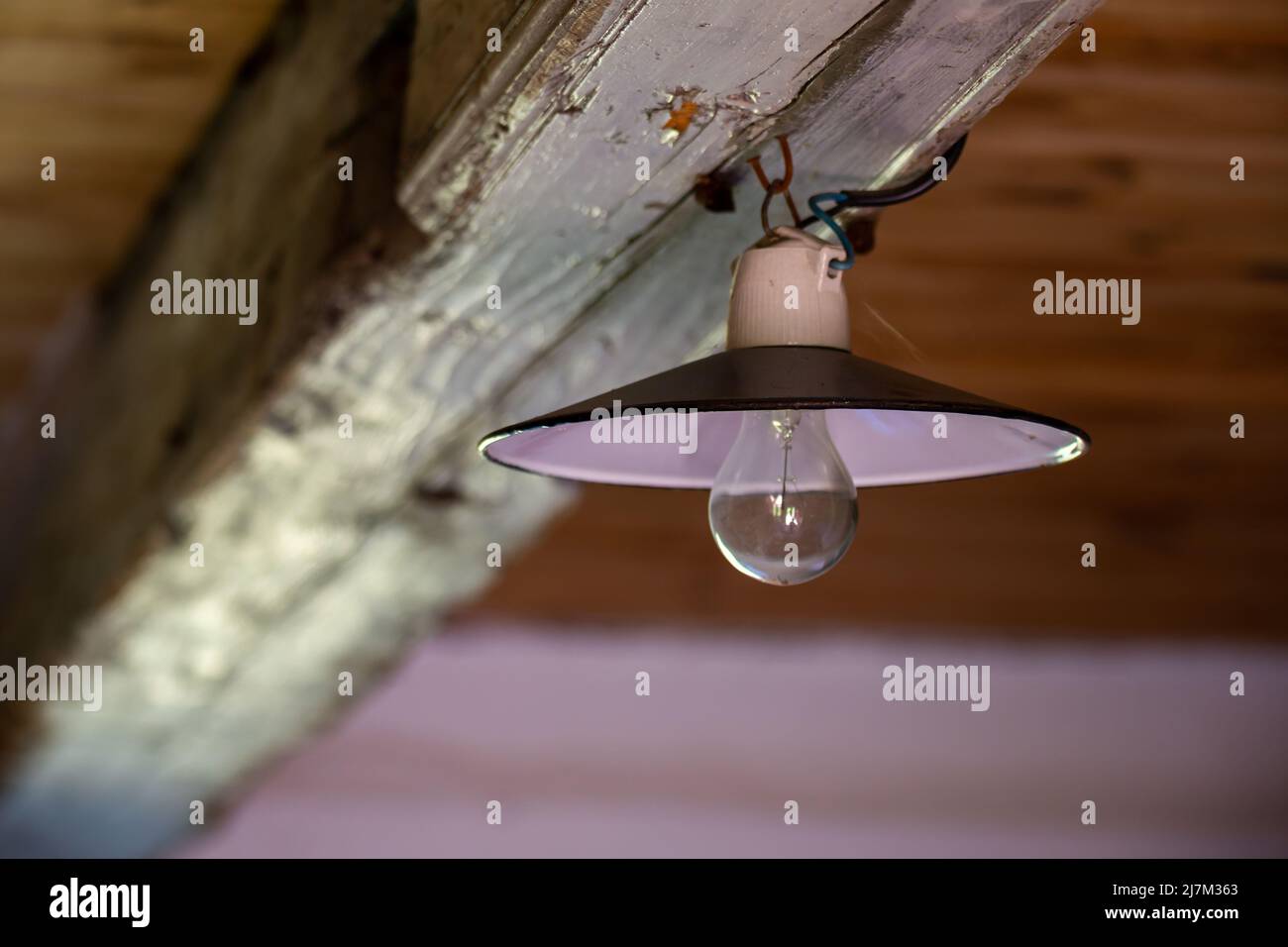 Old electric lamp on the ceiling of an abandoned wooden house. Photo ...