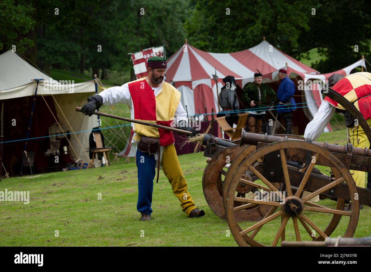 men and women firing muskets and wooden cannons during a re enactment ...